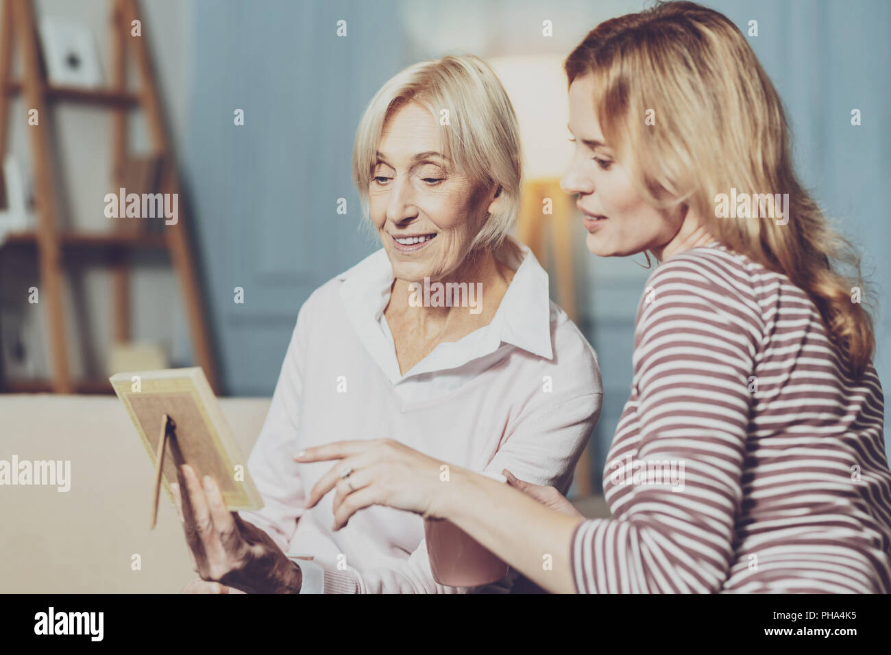 Joyful positive mother and daughter looking at the photo Stock Photo ...