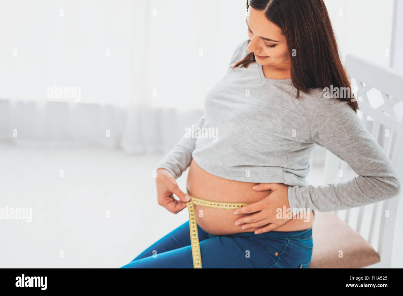 Satisfied smiling woman expecting first child Stock Photo - Alamy