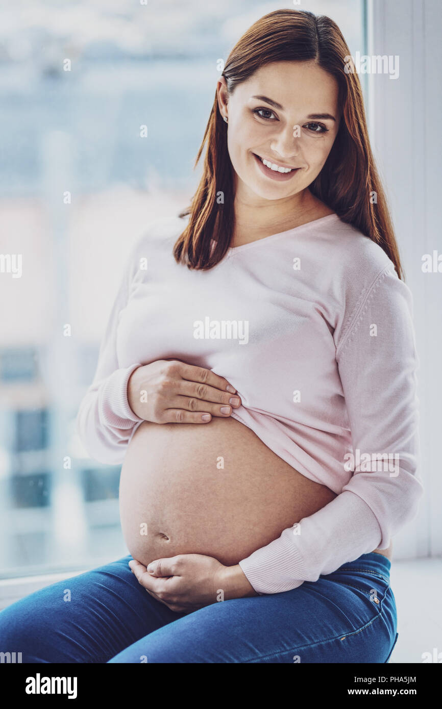 Amazing pregnant woman sitting on window sill Stock Photo - Alamy