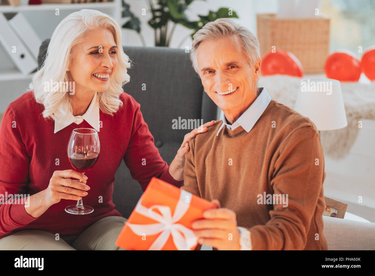 Cheerful male person opening present Stock Photo - Alamy