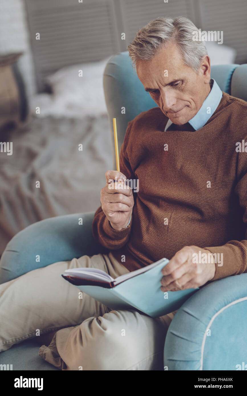 Serious retirement reading his book Stock Photo - Alamy