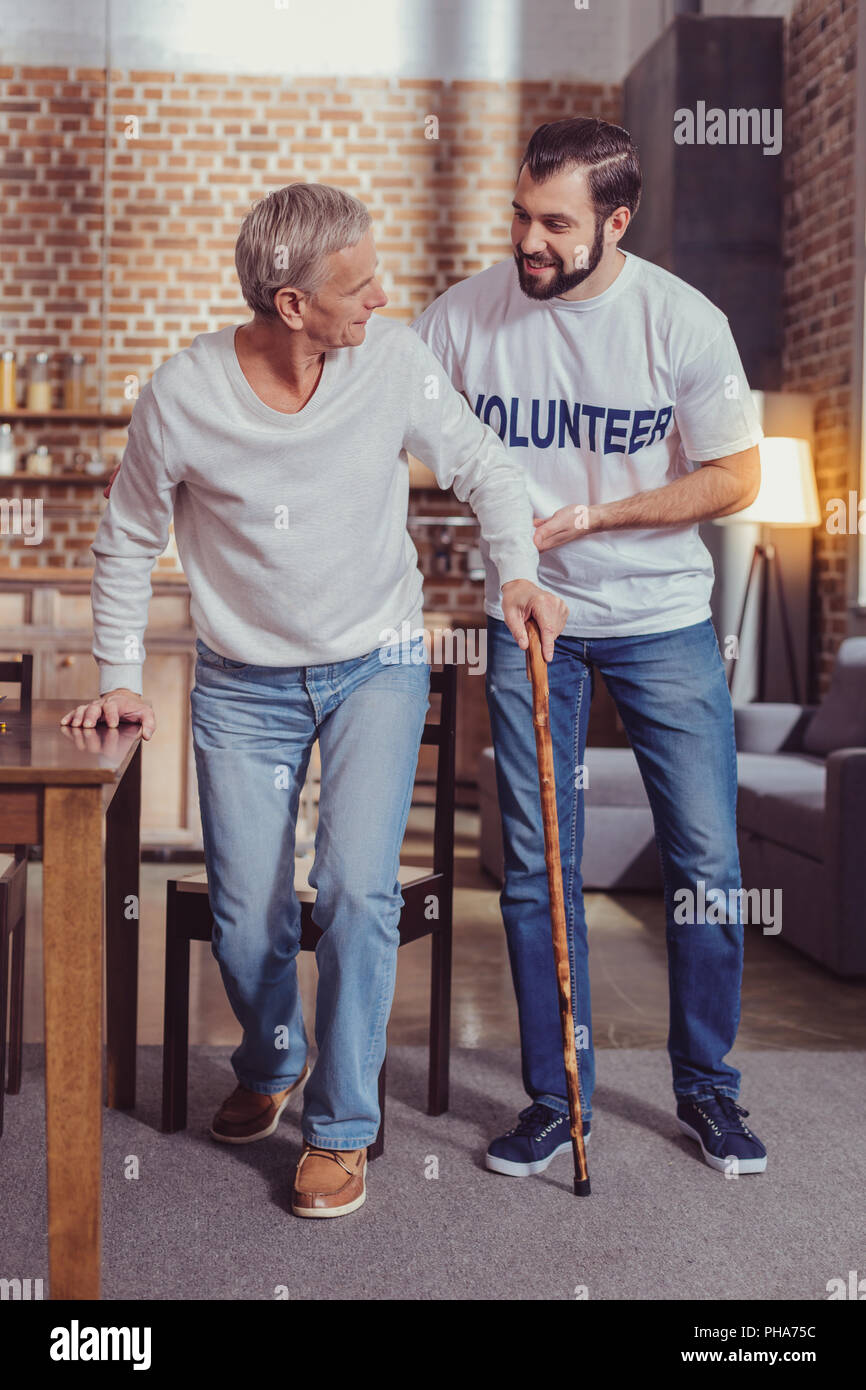 Reliable unshaken man helping retired and supporting him Stock Photo ...