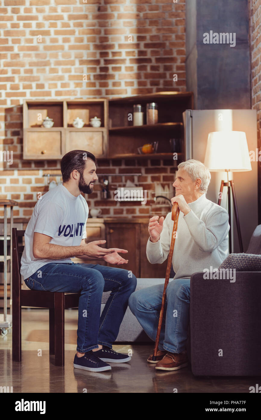 Sociable attentive man sitting and talking to a retired Stock Photo - Alamy