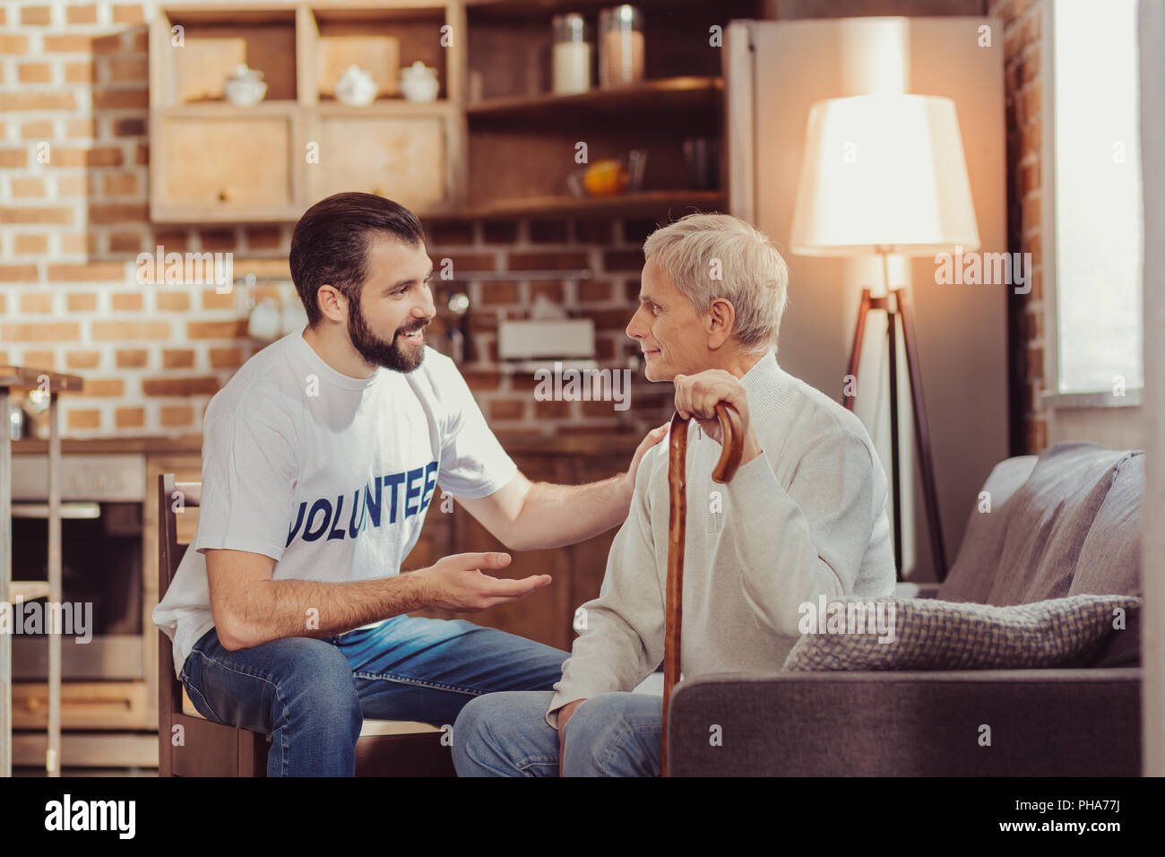 Careful pleasant man smiling and having conversation Stock Photo - Alamy