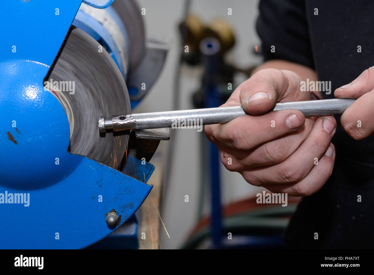 Engineer working on metal at grinding machine - detail Stock Photo - Alamy