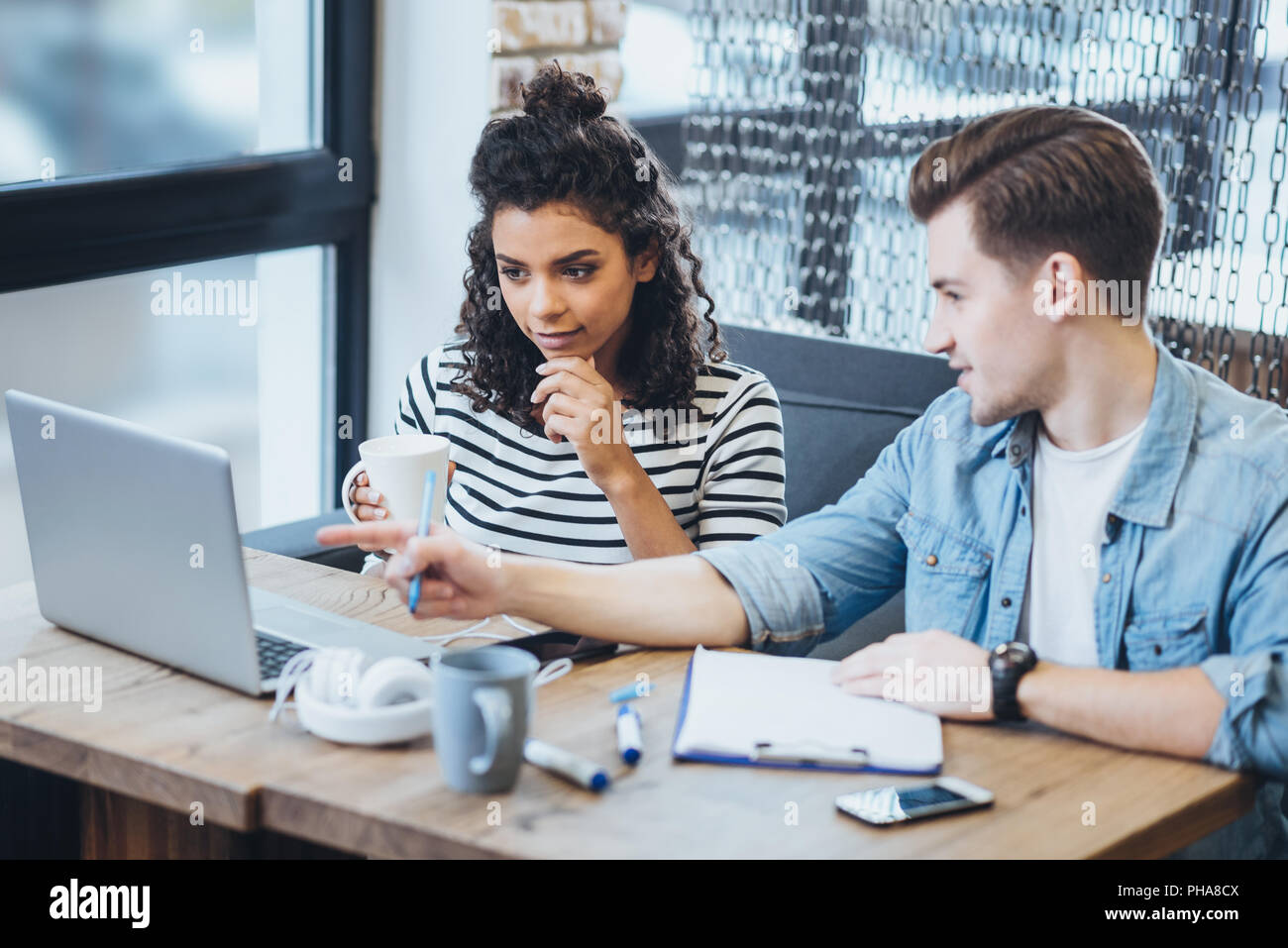 Pensive two students discussing task Stock Photo - Alamy