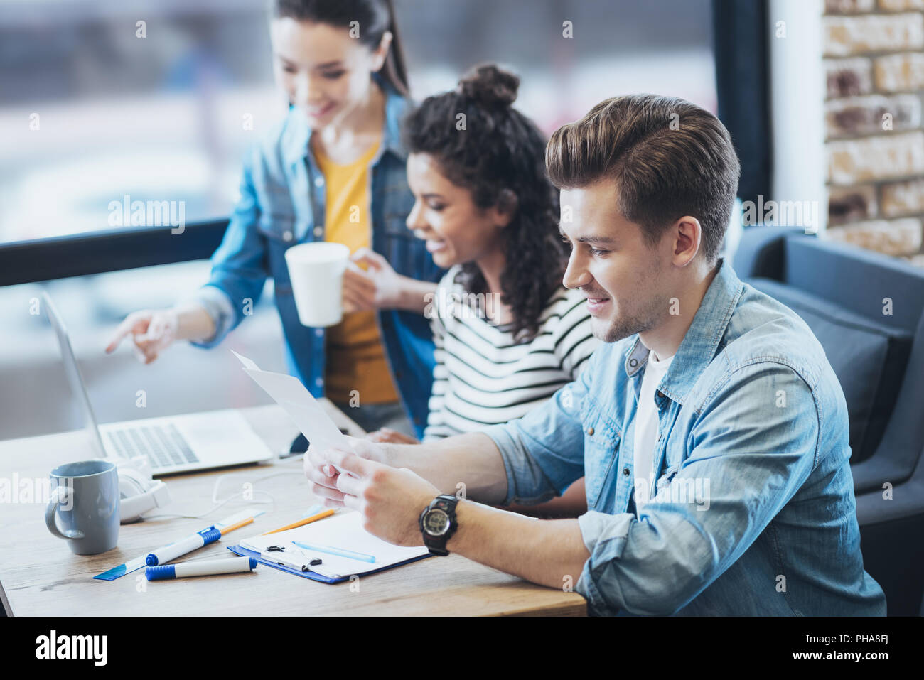 Cheerful three students uniting efforts Stock Photo - Alamy