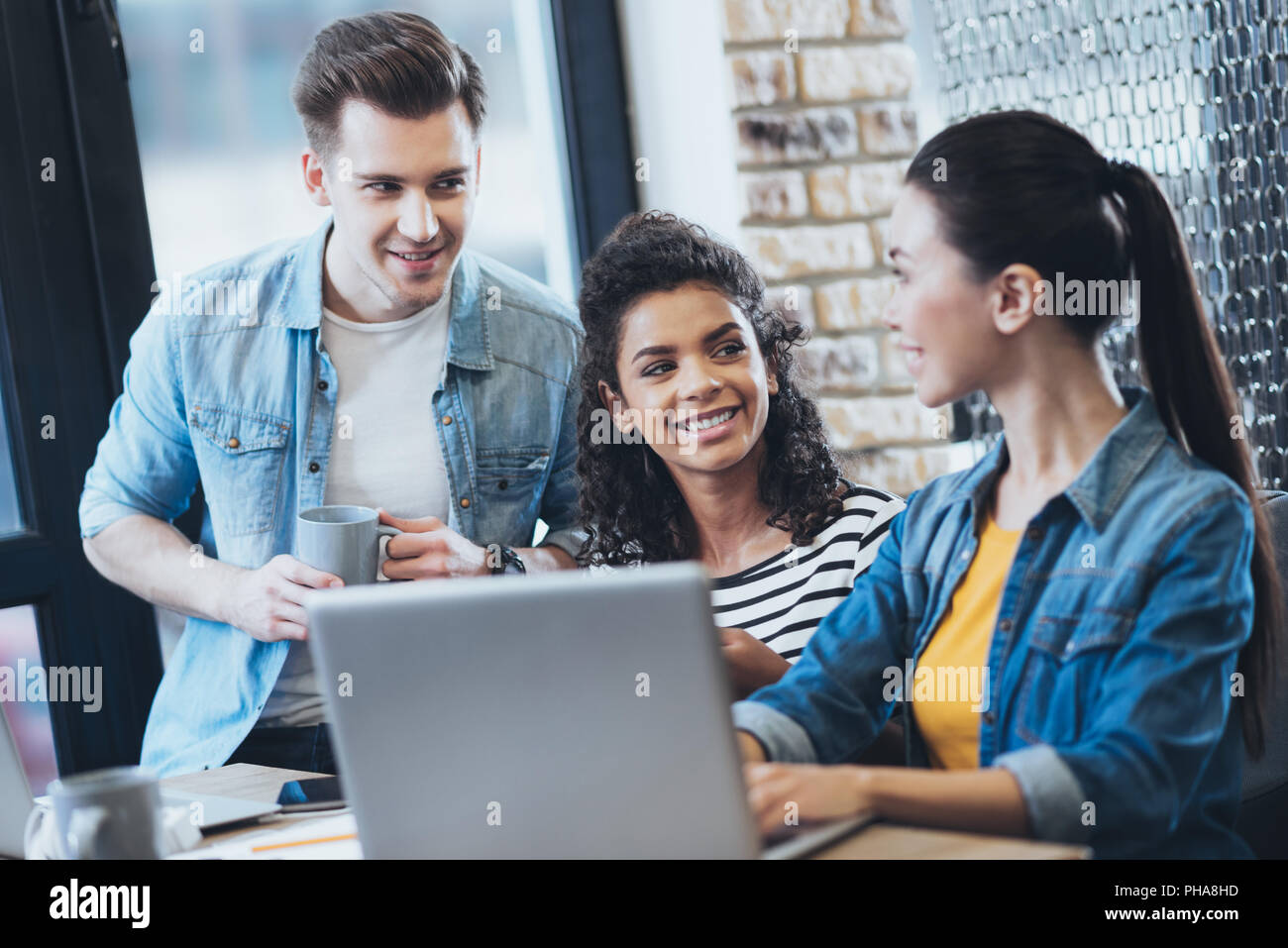 Enthusiastic three students exchanging ideas Stock Photo - Alamy