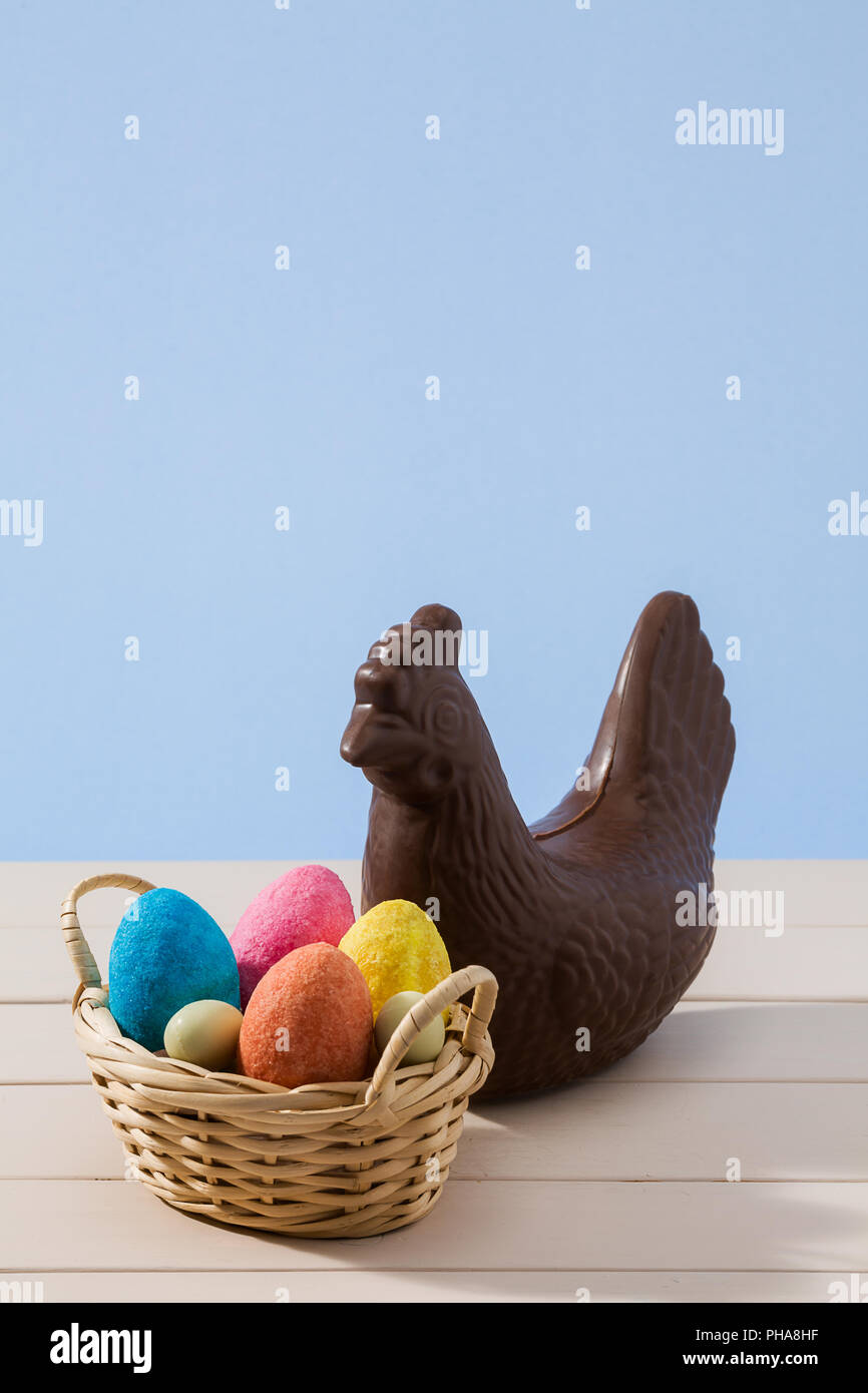 Easter chocolate chicken and colored eggs over a white table Stock ...