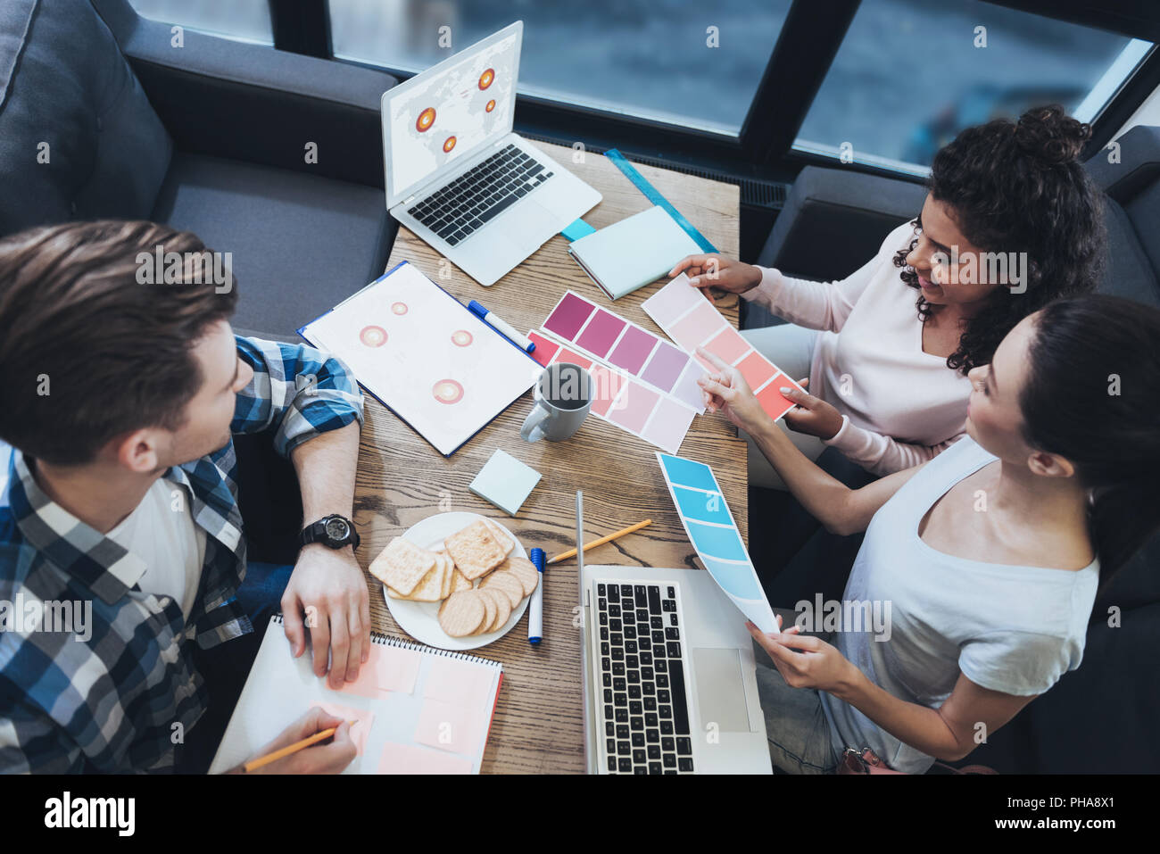 Pensive three colleagues choosing color Stock Photo - Alamy