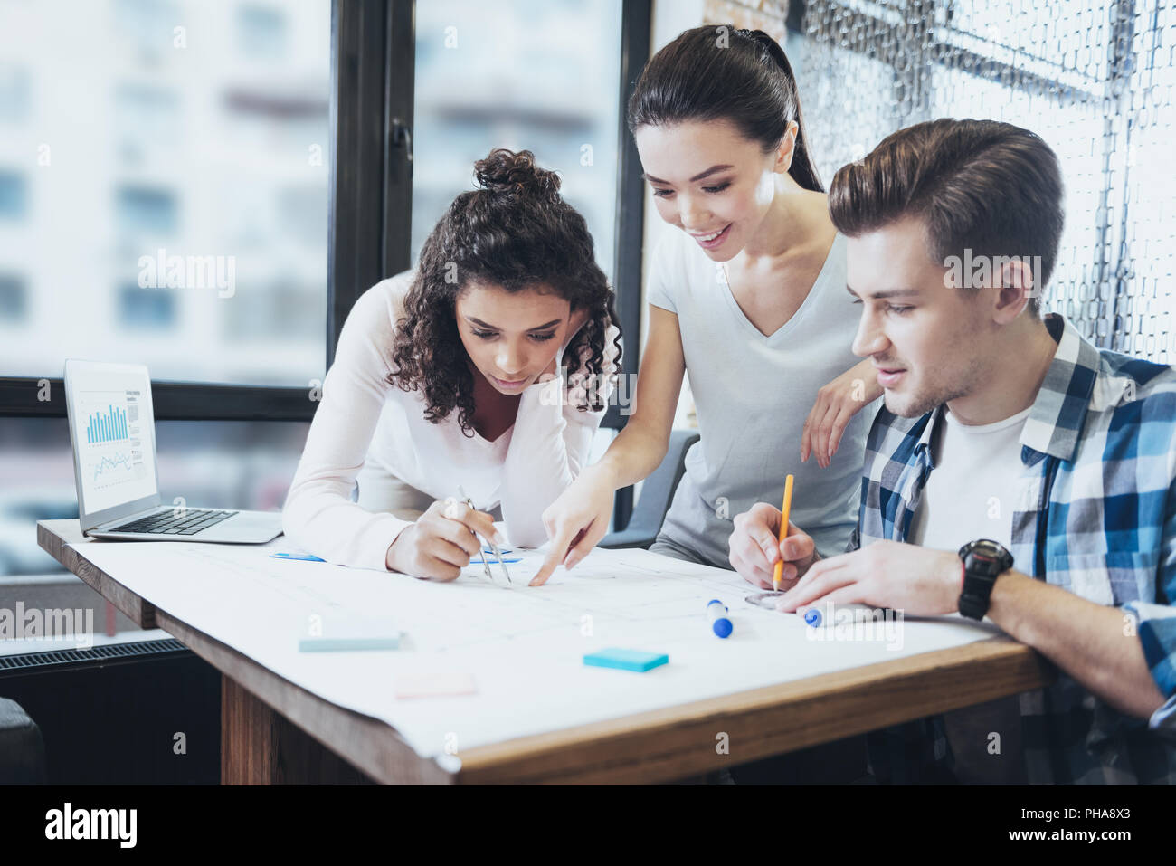 Thoughtful three colleagues calculating scale Stock Photo - Alamy