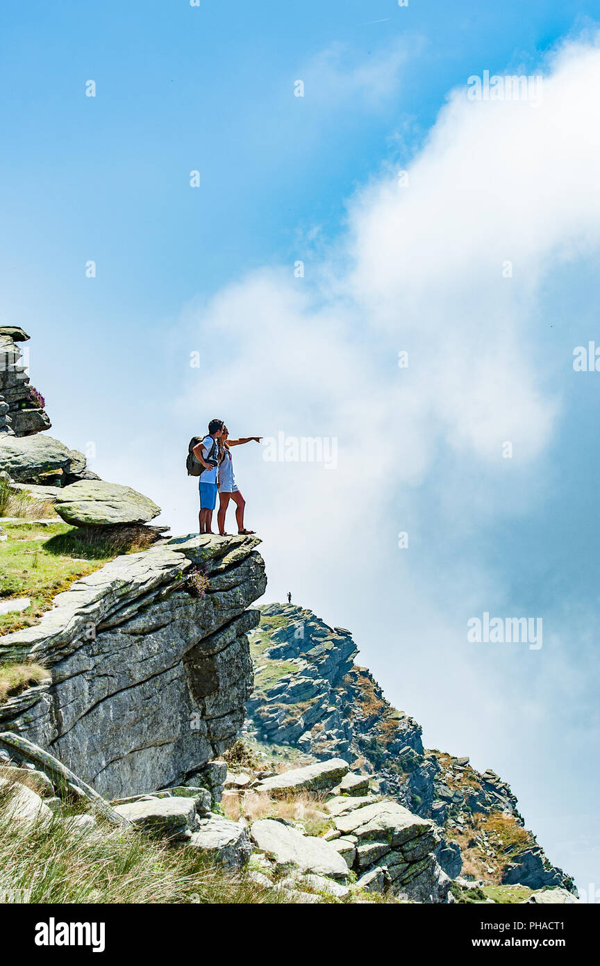Couple sitting on cliff top hi-res stock photography and images - Alamy