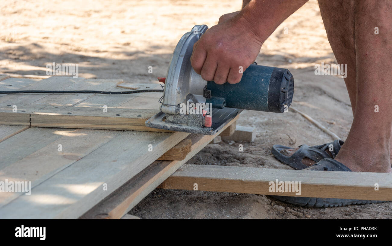Building a formwork for the fence. Carpenter using a circular saw to ...