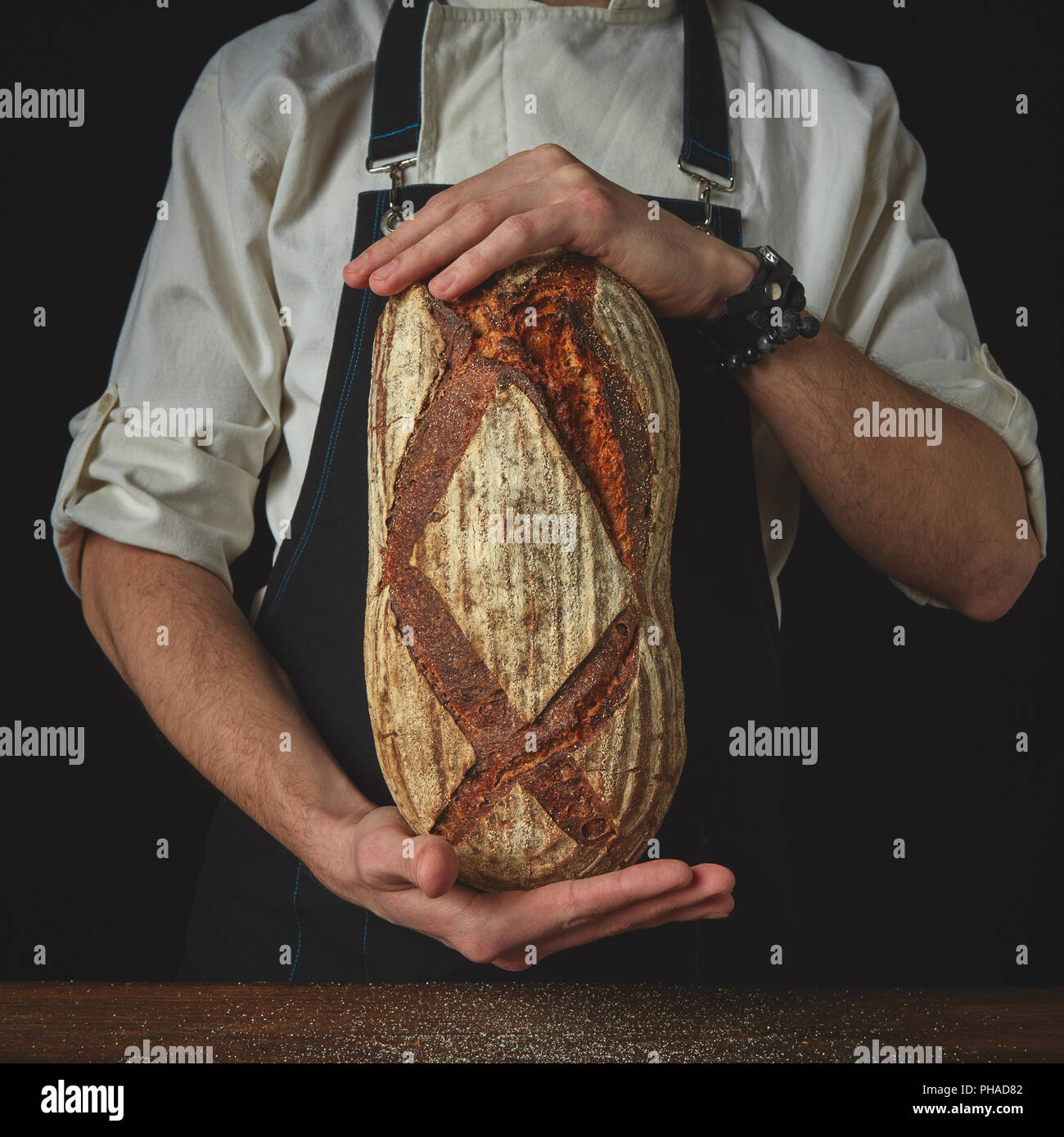 Hands of man holding oval bread Stock Photo - Alamy