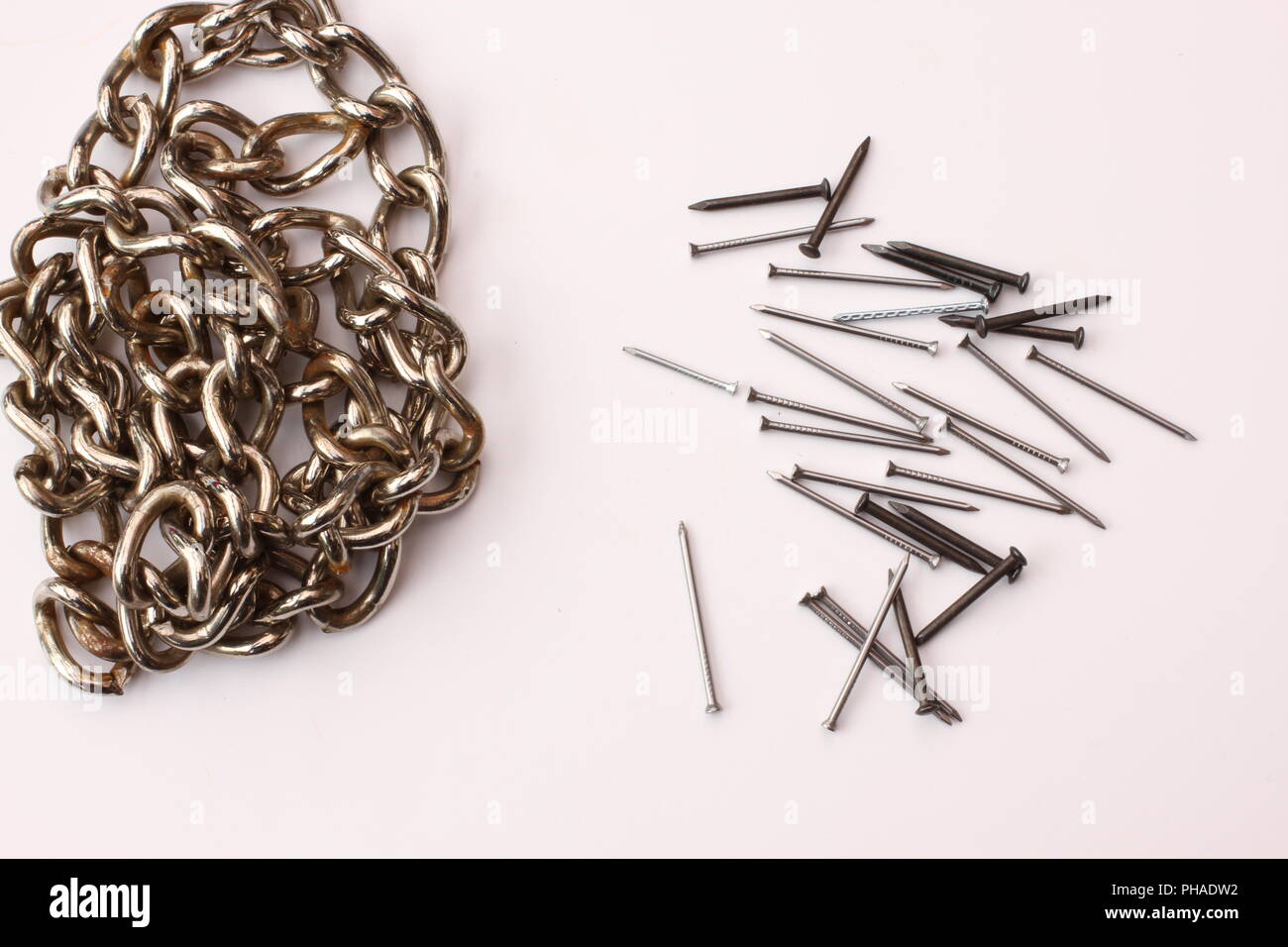 Metal Chain and Nails on white background Stock Photo - Alamy