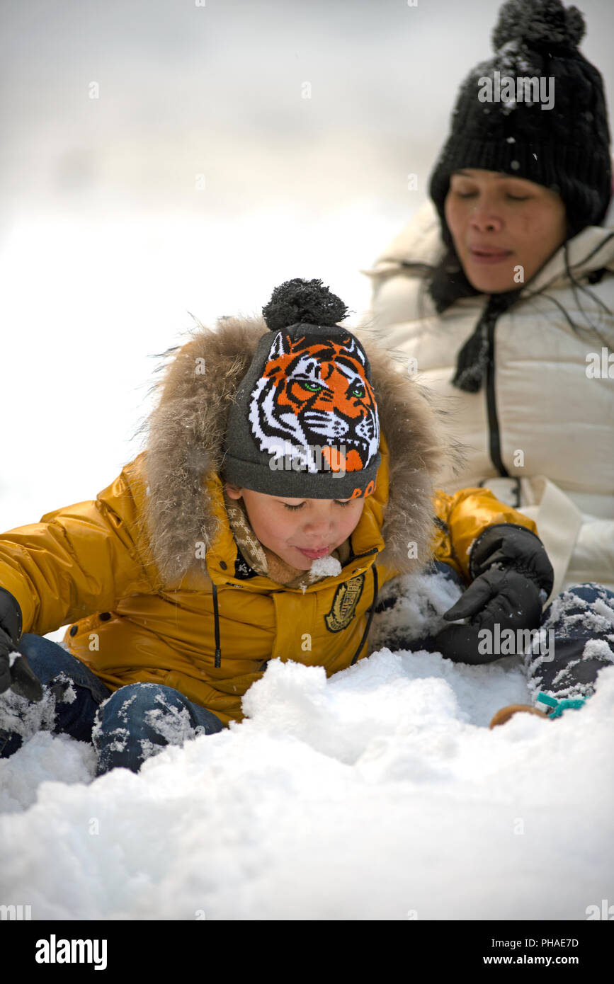 Child playing and eating snow Stock Photo - Alamy