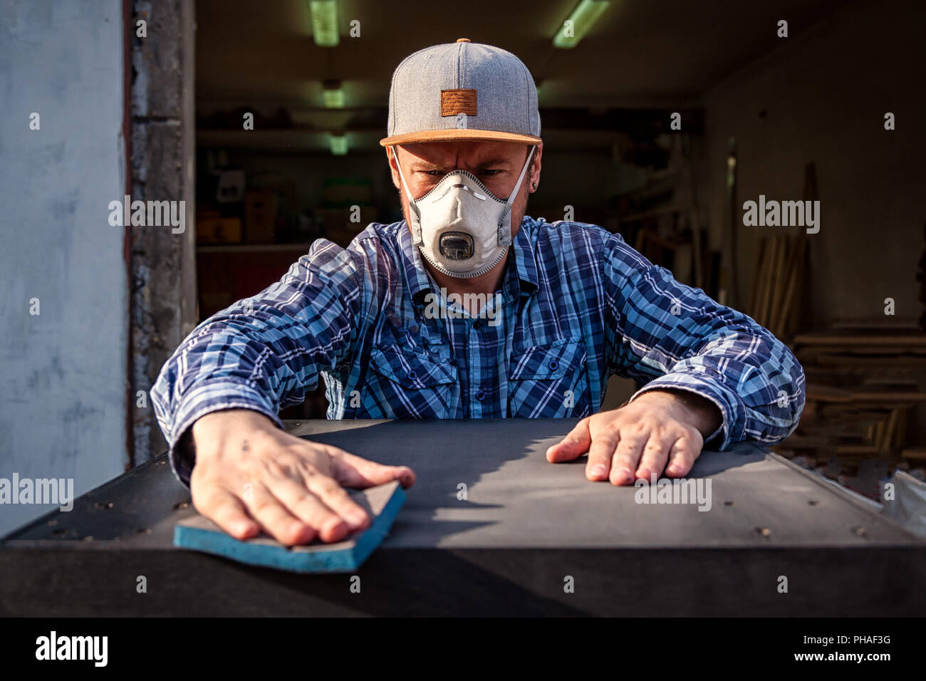 Strong man in work clothes hard working and washes, polishes a rag with ...