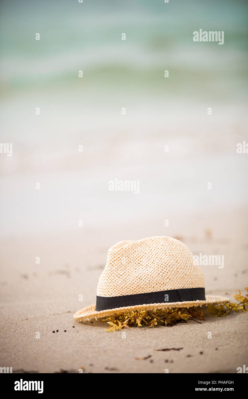 Nice straw hat laying on the sand. Beautiful ocean beach background ...