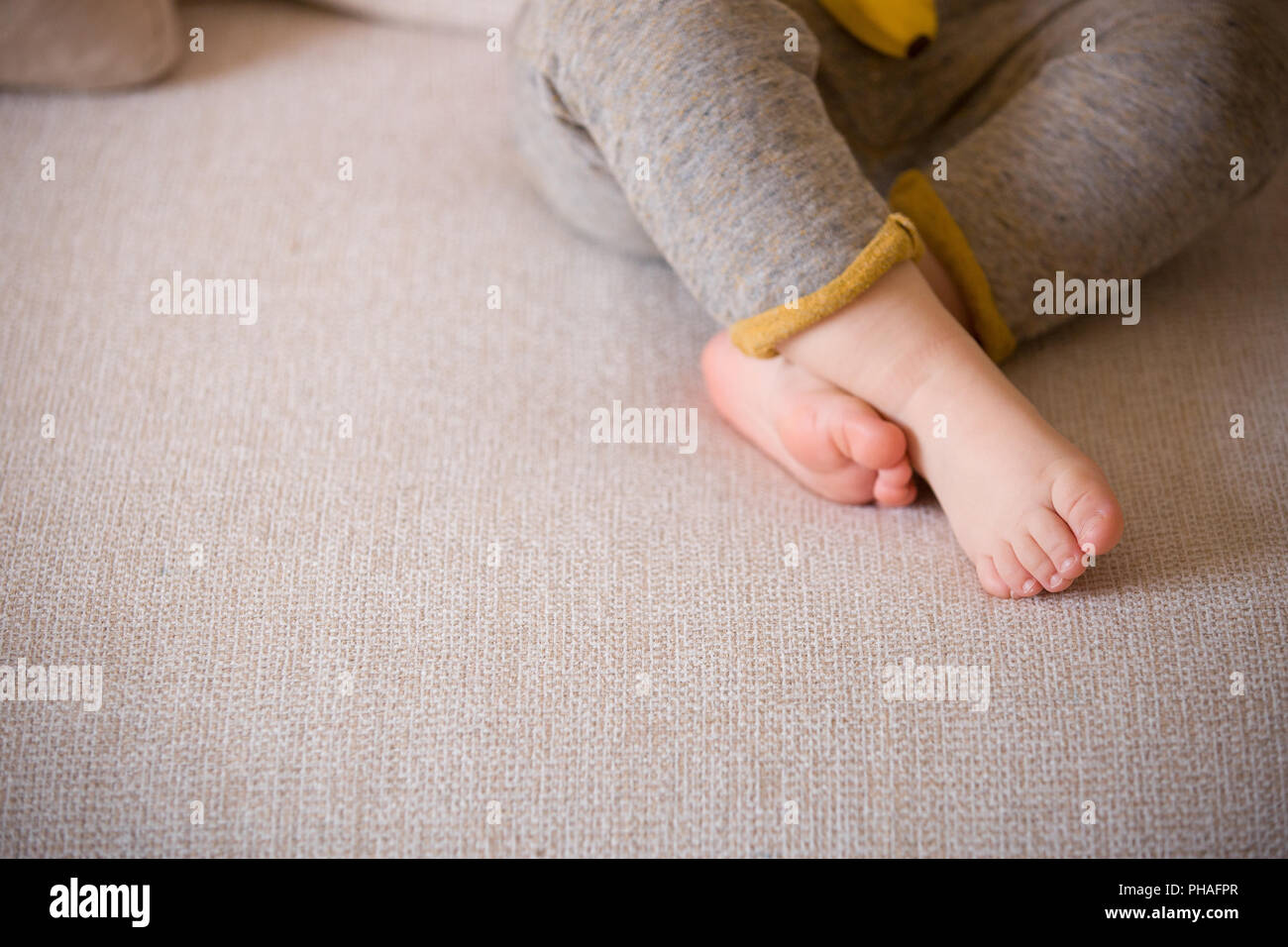 Close up baby legs. Baby feet on the sofa. Barefoot Stock Photo - Alamy
