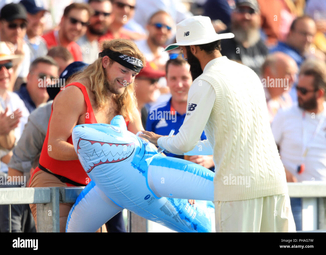 England's Moeen Ali signs an autograph during day two of the fourth ...