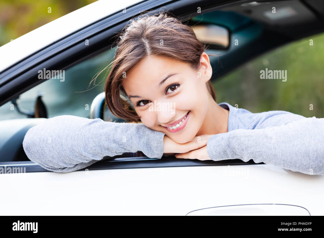 Happy owner of a new car smiling to you. Pretty girl driver Stock Photo ...