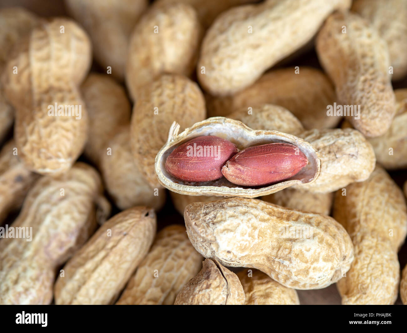 Closeup dried peanuts in shells on peanuts background on wooden table ...