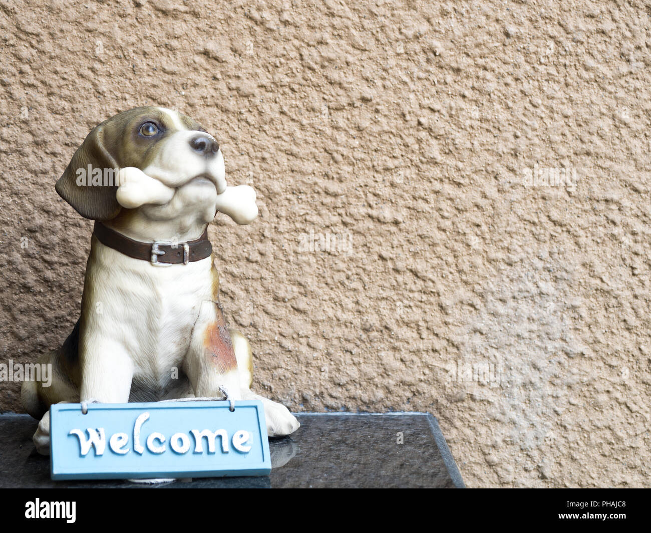 Sculpture dog bite bone and have blue welcome sign in front Stock Photo ...