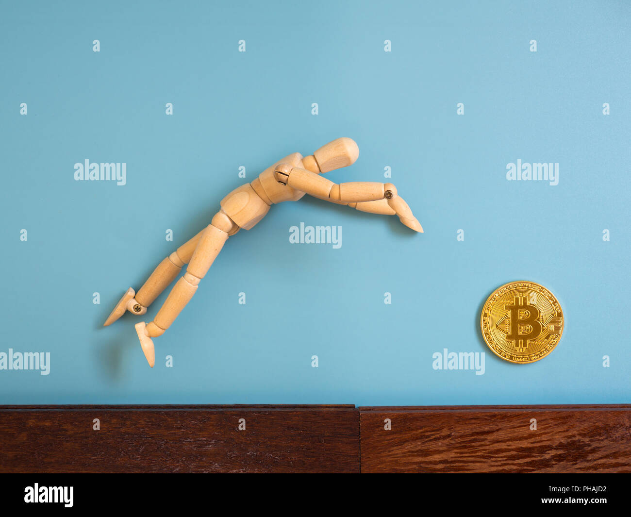 Wooden puppet jumping from the wooden floor in the air to catch the ...