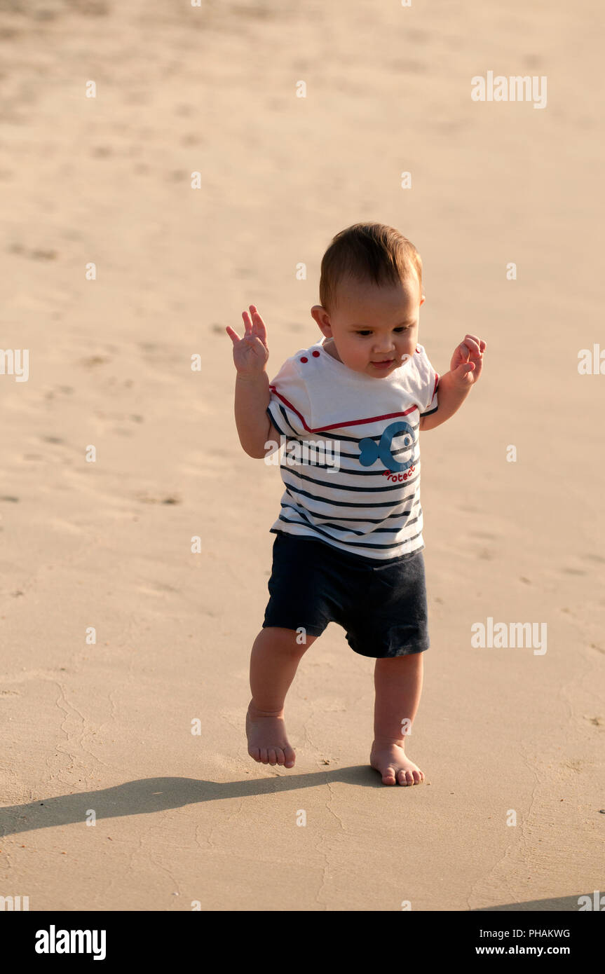 Baby on the beach - First steps on the sand Stock Photo - Alamy