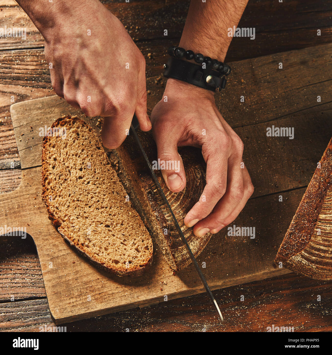 Men's hands cut fresh bread Stock Photo - Alamy