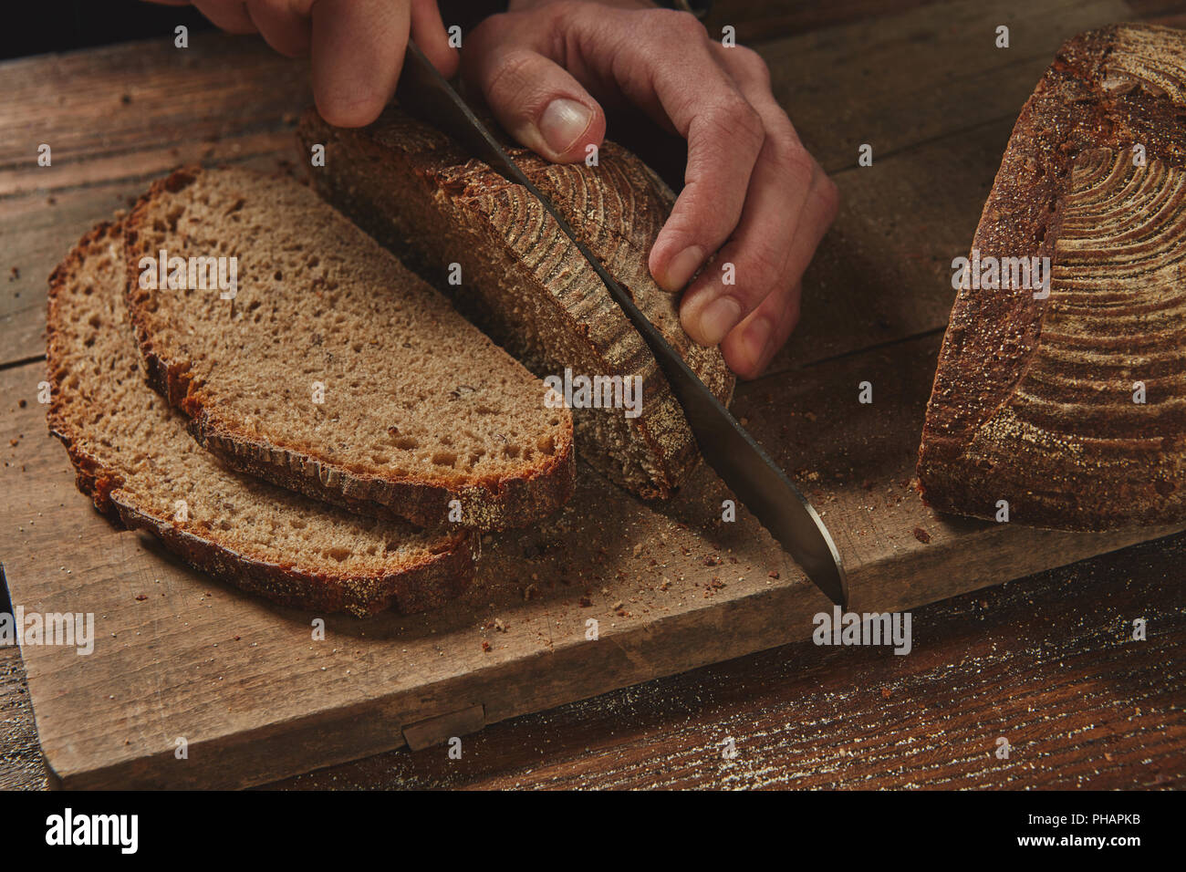 male chef's hand cutting Rye bread Stock Photo - Alamy