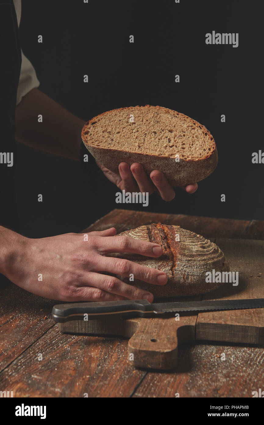 Hands holding half bread Stock Photo - Alamy