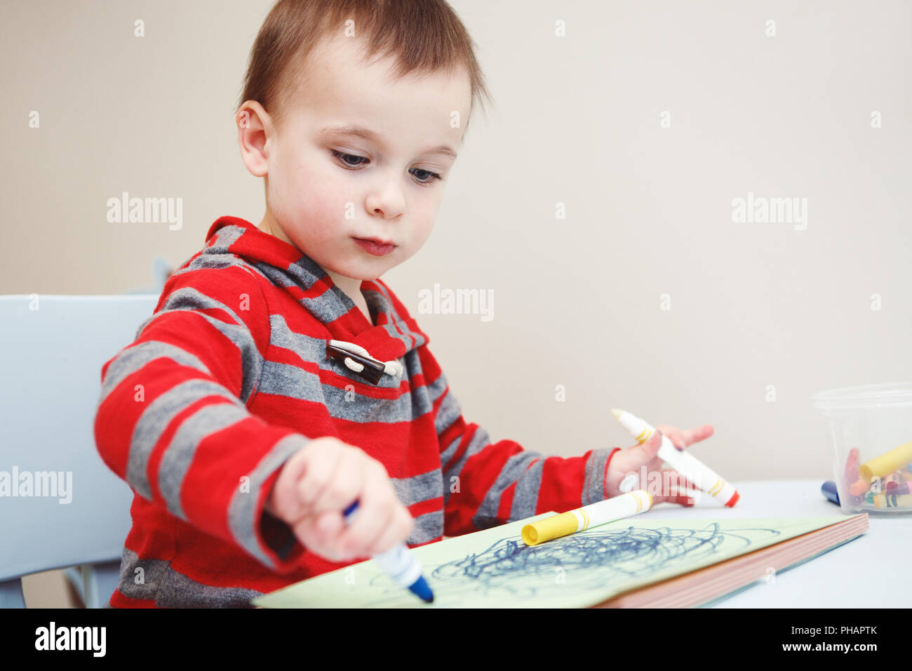 Portrait of cute Caucasian white little boy toddler drawing with color ...
