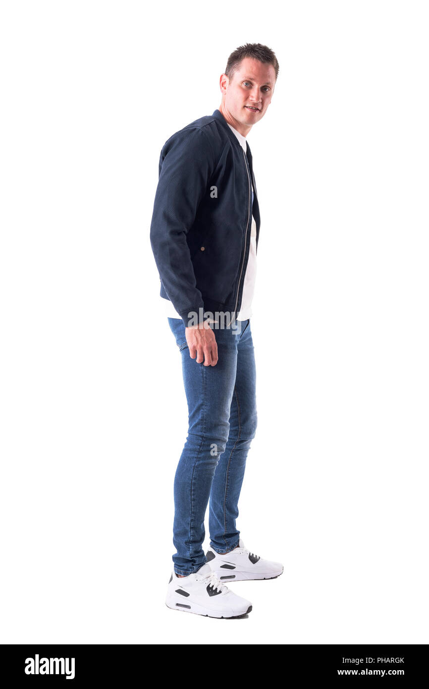 Surprised young adult handsome man in bomber jacket looking at camera ...