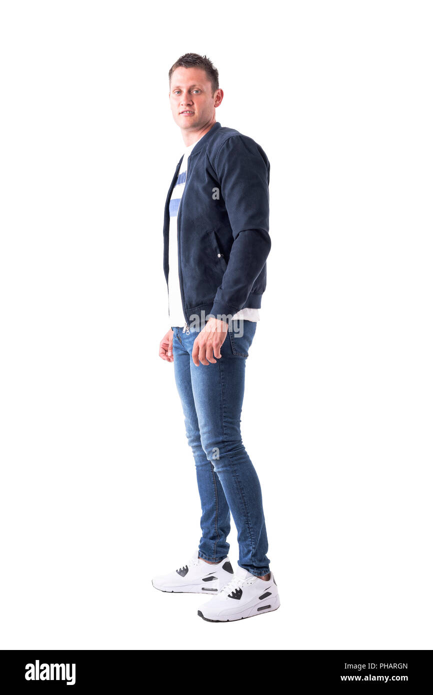 Side view of casual adult man in bomber jacket and jeans with arms down ...