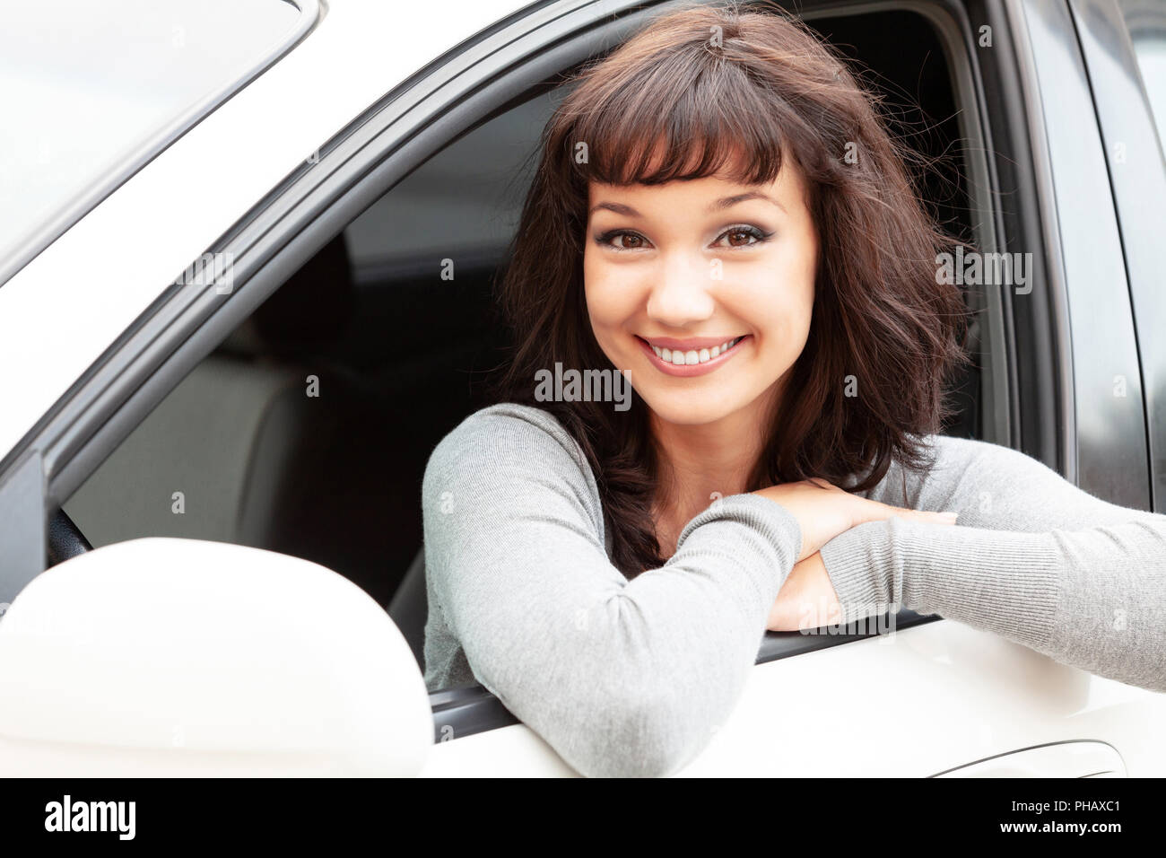 Happy owner of a new car smiling to you. Pretty girl driver Stock Photo ...