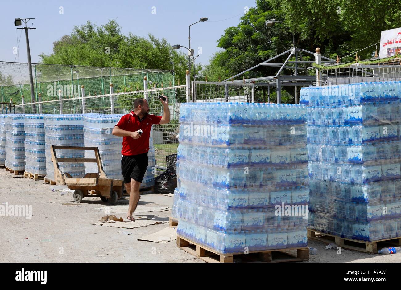 Baghdad, Iraq. 30th Aug, 2018. A worker prepares to deliver bottles of ...