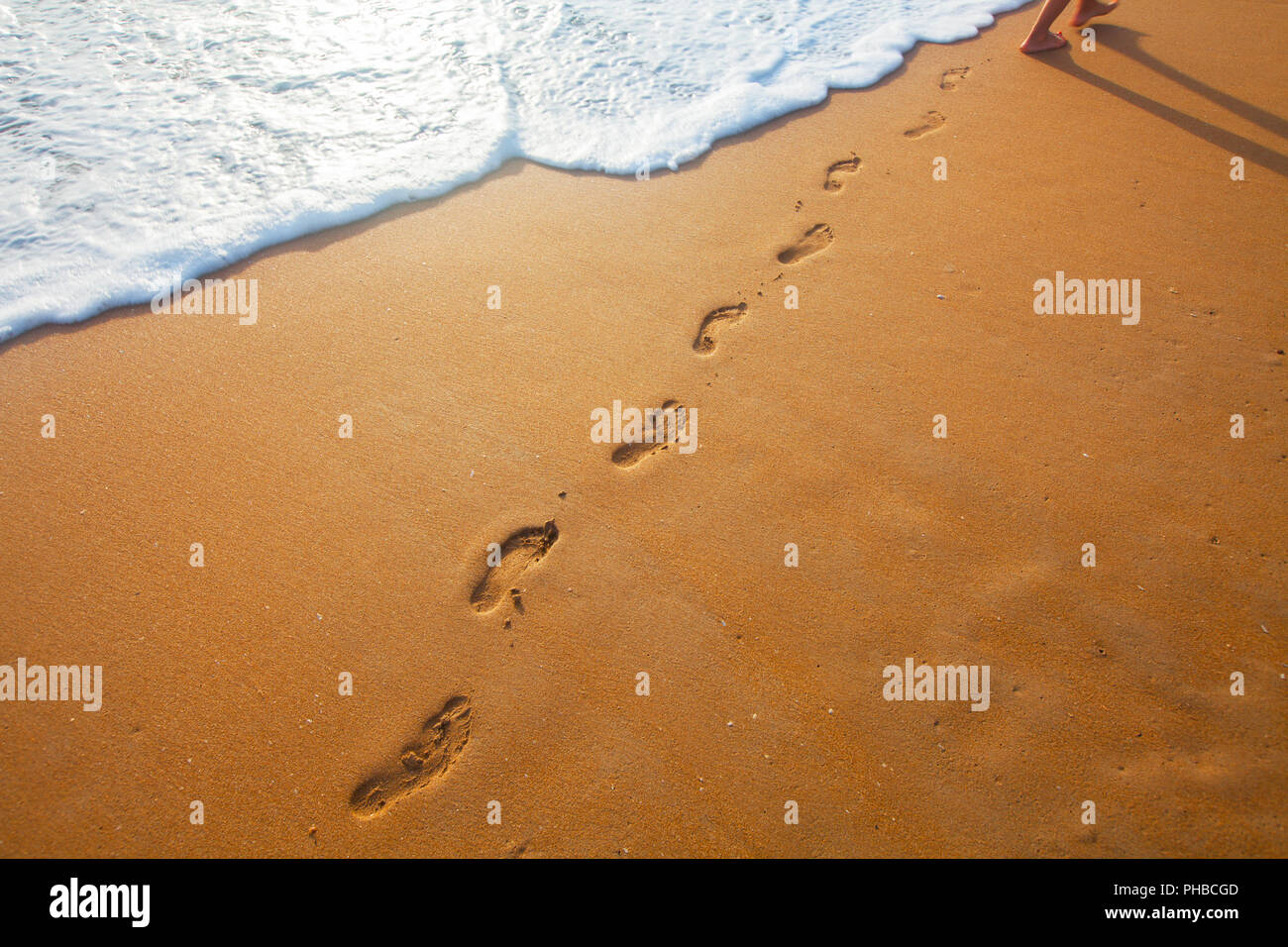 beach, wave and footprints at sunset time Stock Photo - Alamy