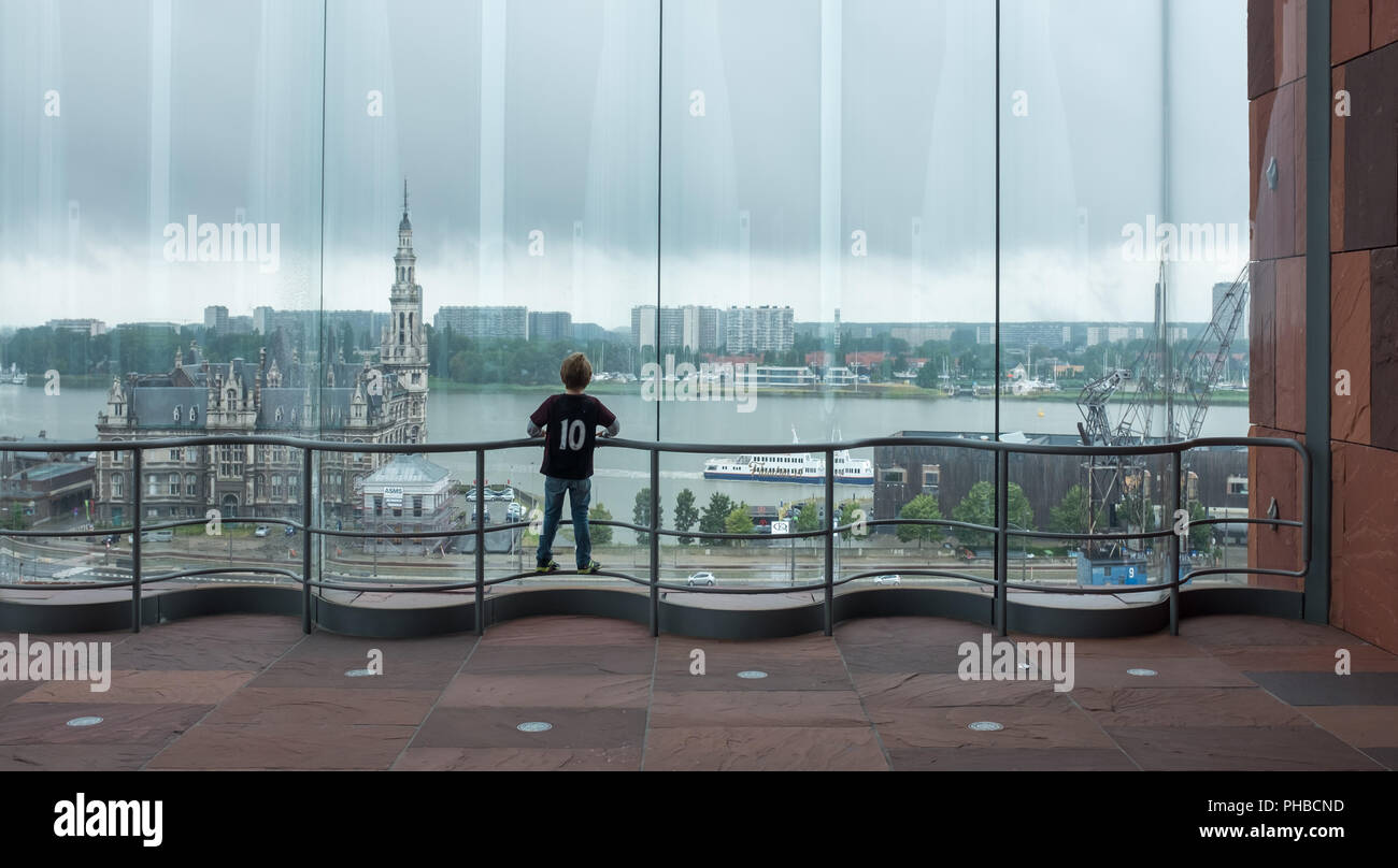 Boy looking through the window of the MAS museum on a rainy day, Sunday ...