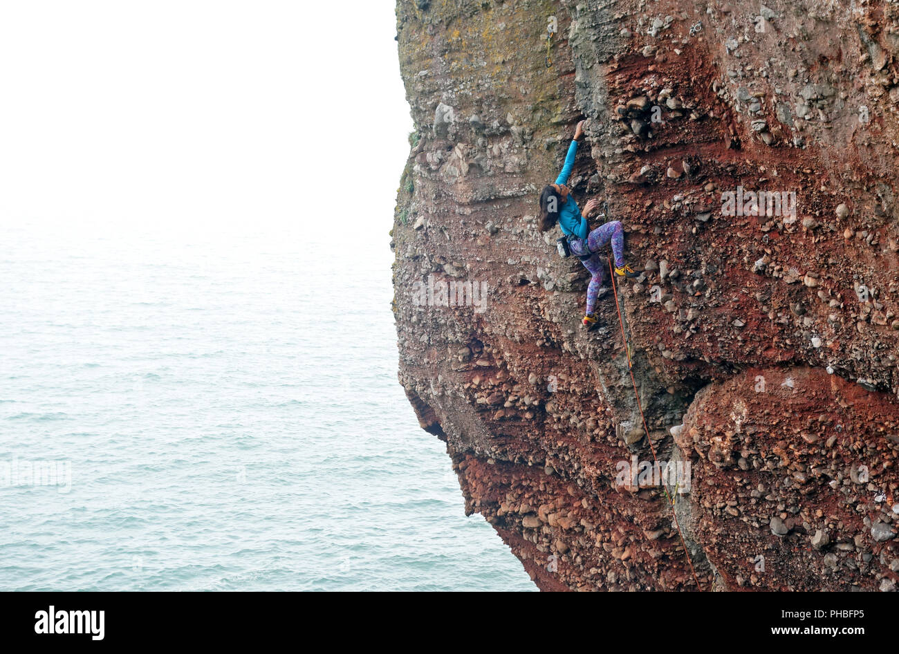 Rock climber in action, Watcombe Beach, South Devon, England, United ...