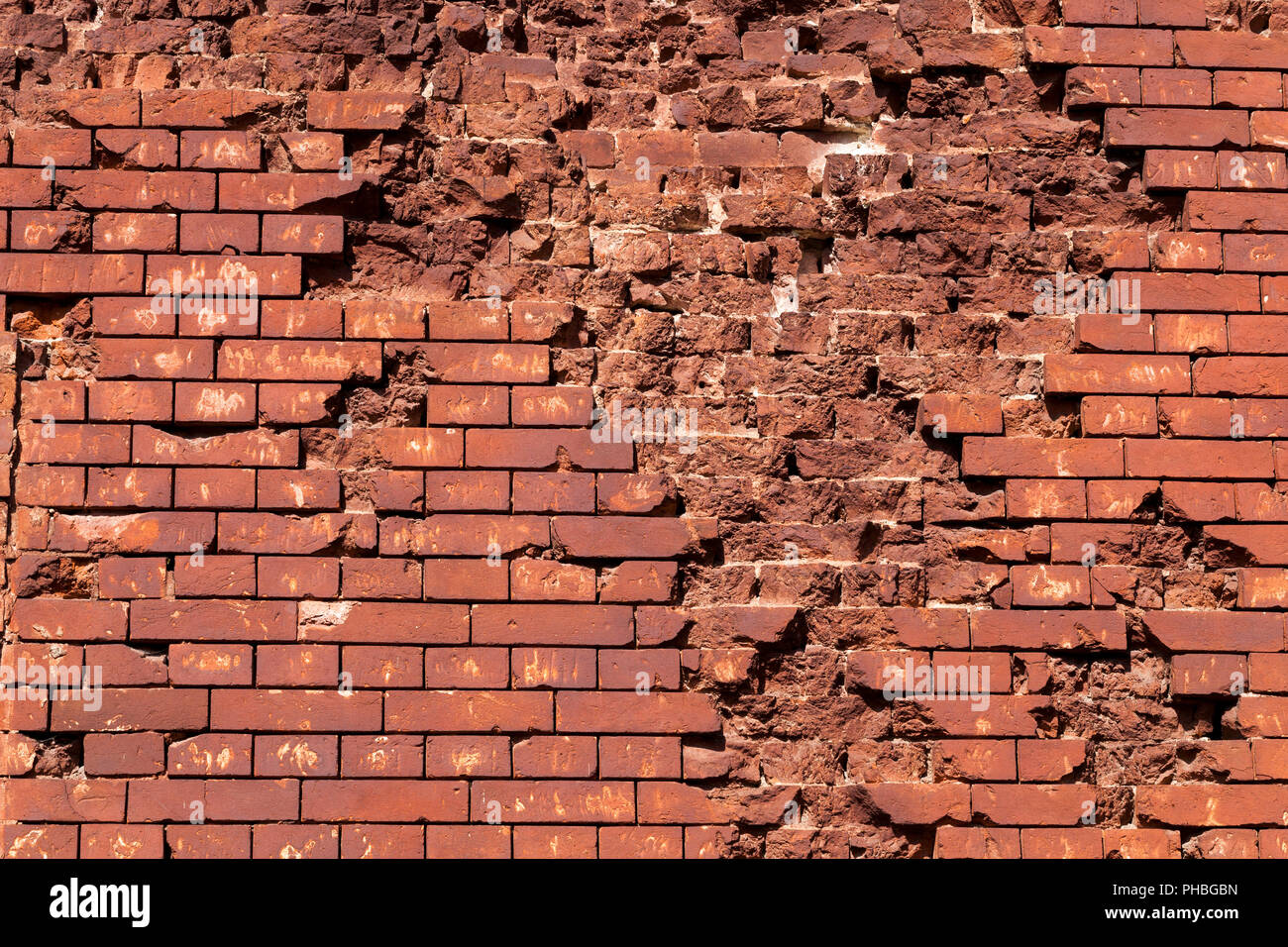 old damaged by bullets and shells brick red wall of the ancient ...
