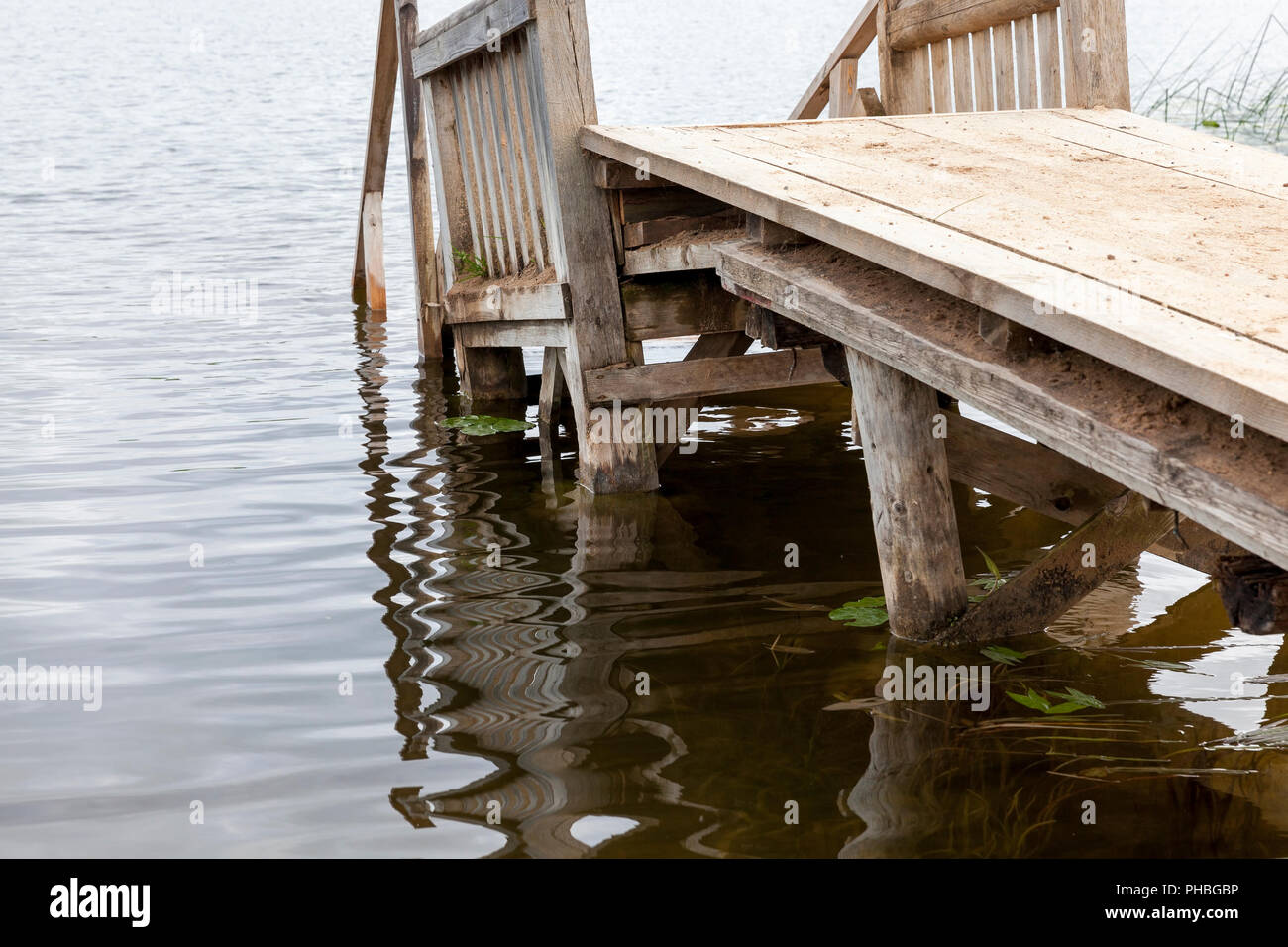 wooden pier from the planks near the lake with dark water, made in the ...