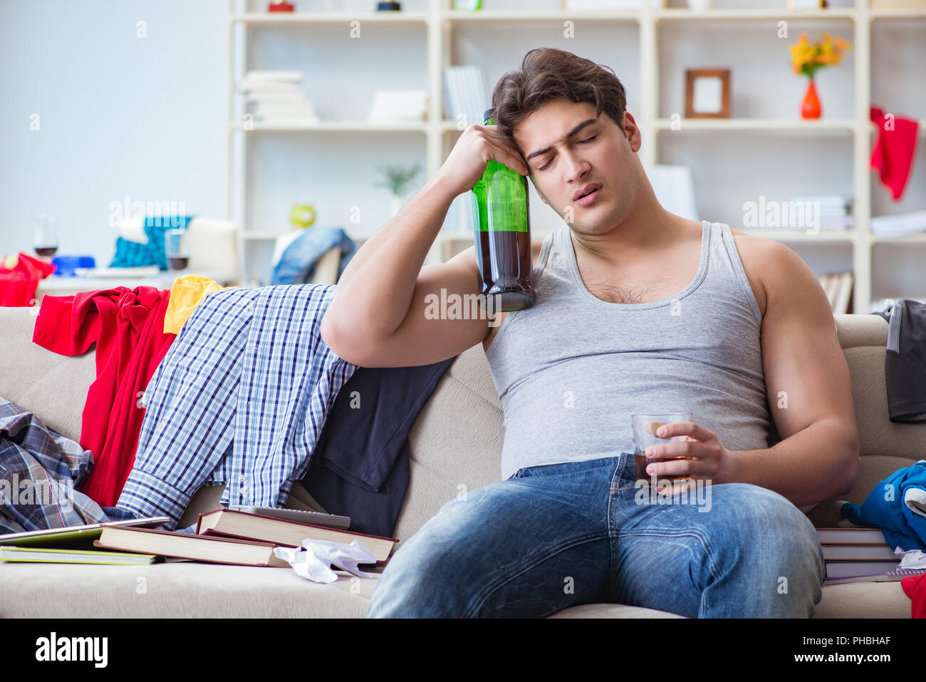 Young man student drunk drinking alcohol in a messy room Stock Photo ...