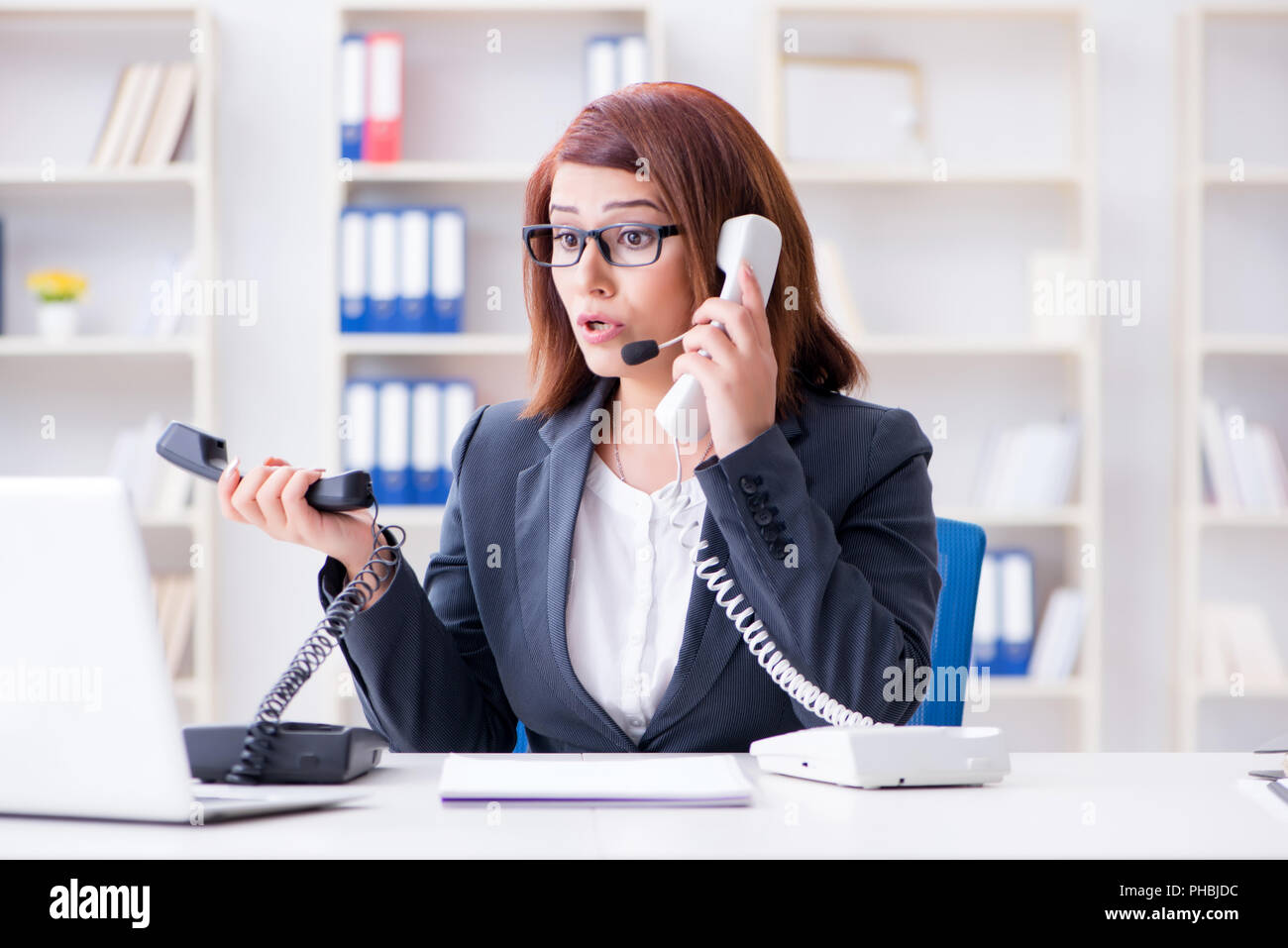 Frustrated call center assistant responding to calls Stock Photo - Alamy