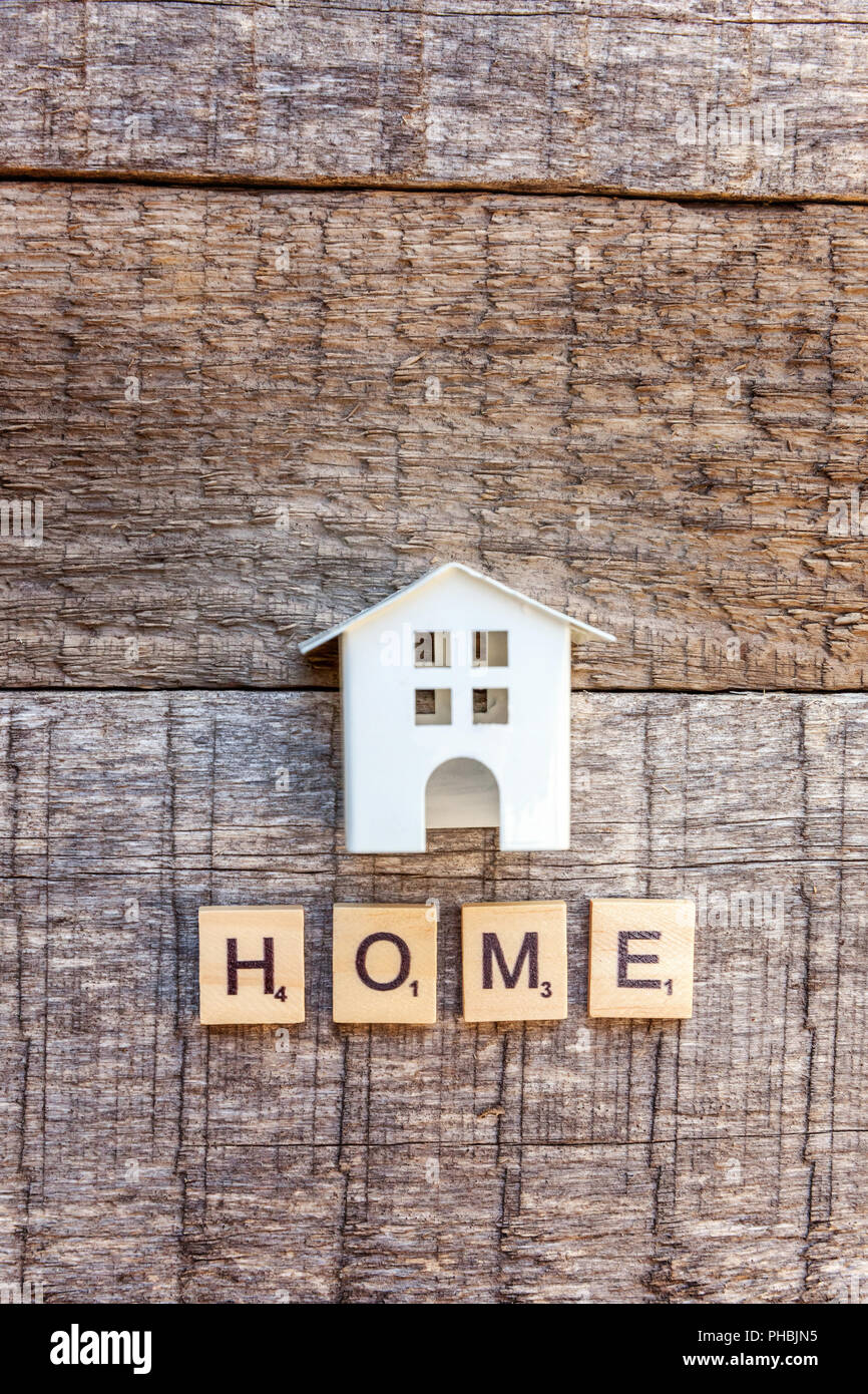 Miniature toy model house with inscription HOME letters word on wooden ...