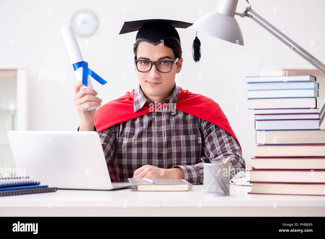 Super hero student wearing a mortarboard studying Stock Photo - Alamy