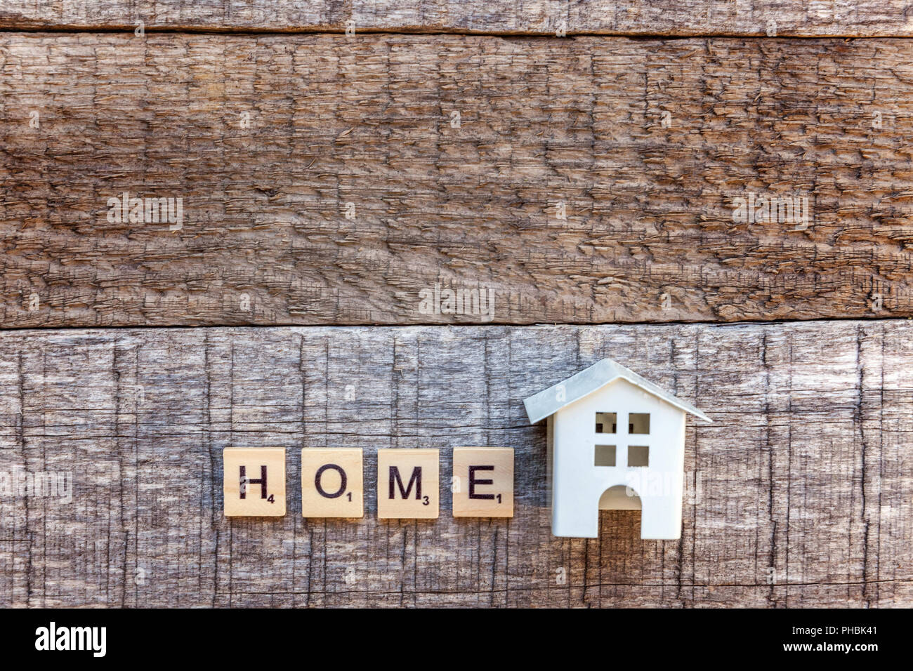 Miniature toy model house with inscription HOME letters word on wooden ...