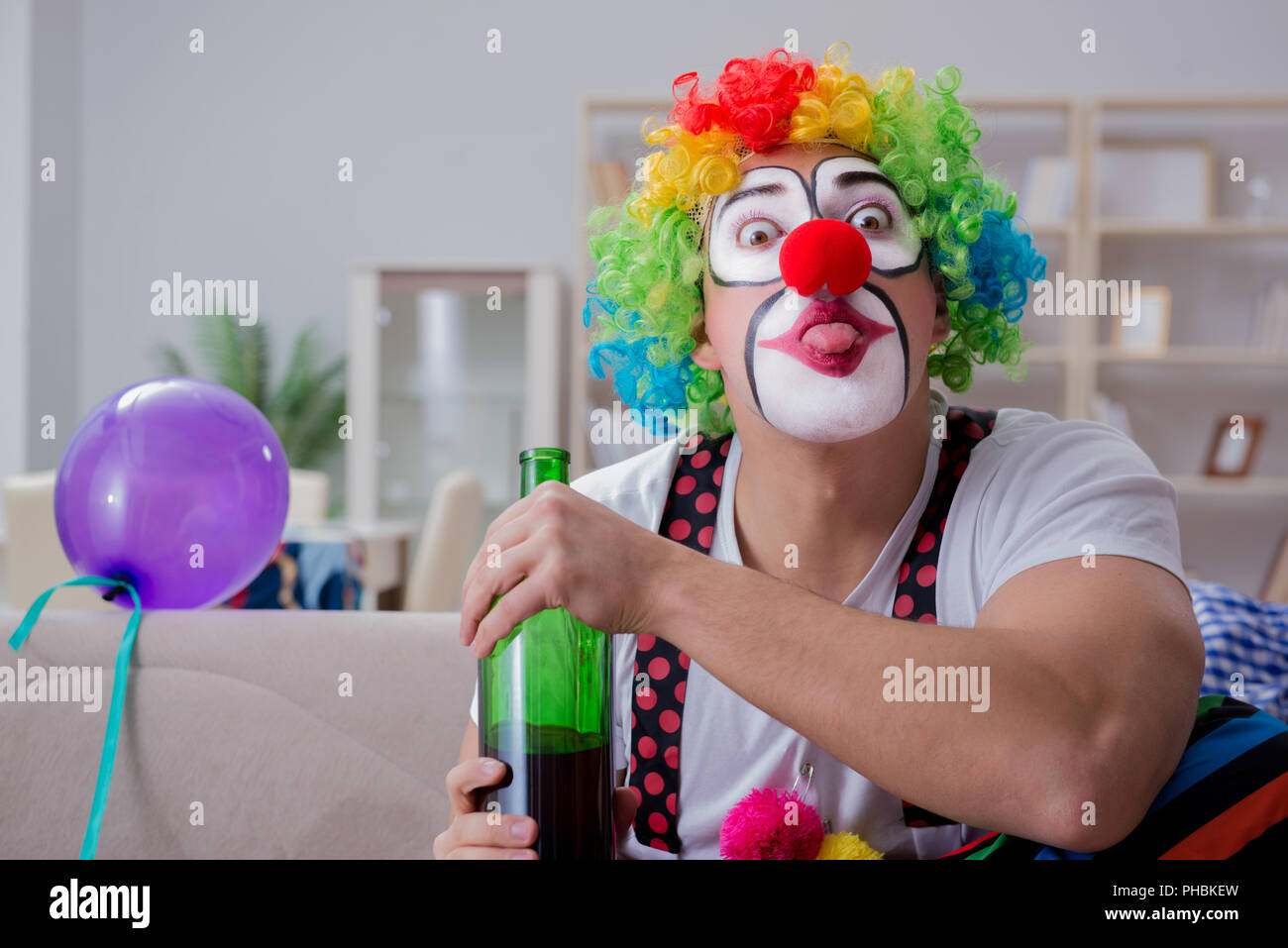 Drunk clown celebrating having a party at home Stock Photo - Alamy