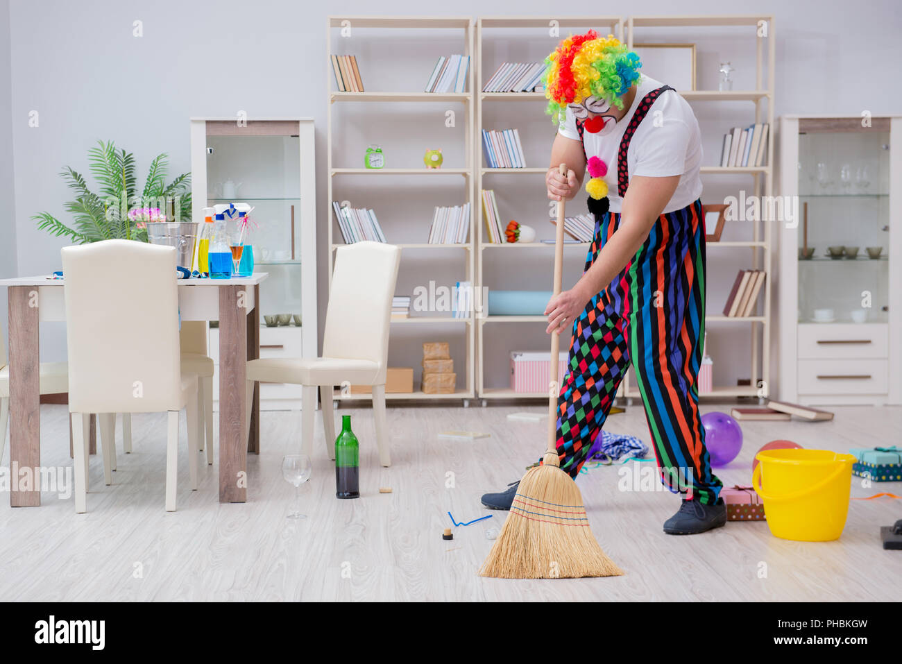 Funny clown doing cleaning at home Stock Photo - Alamy