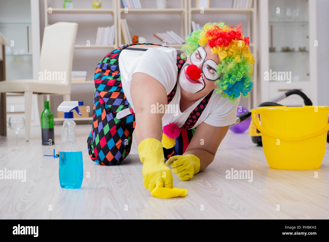 Funny clown doing cleaning at home Stock Photo - Alamy